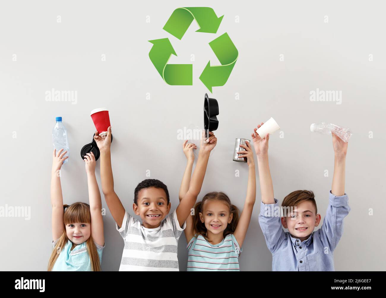 Little children with different trash and symbol of recycling on light ...