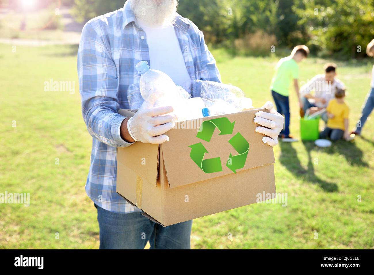 Man with gathered garbage outdoors. Concept of recycling Stock Photo ...