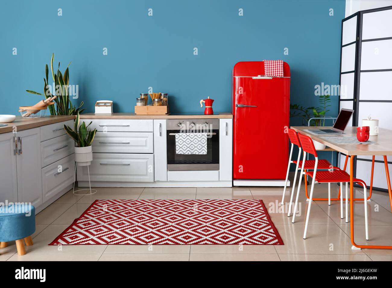 Interior of modern kitchen with red fridge and carpet Stock Photo - Alamy