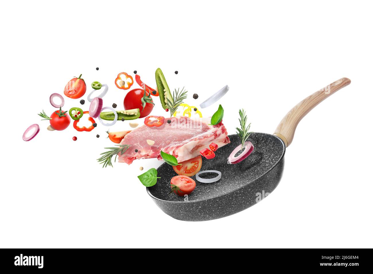 Flying frying pan with raw meat, vegetables and spices on white ...