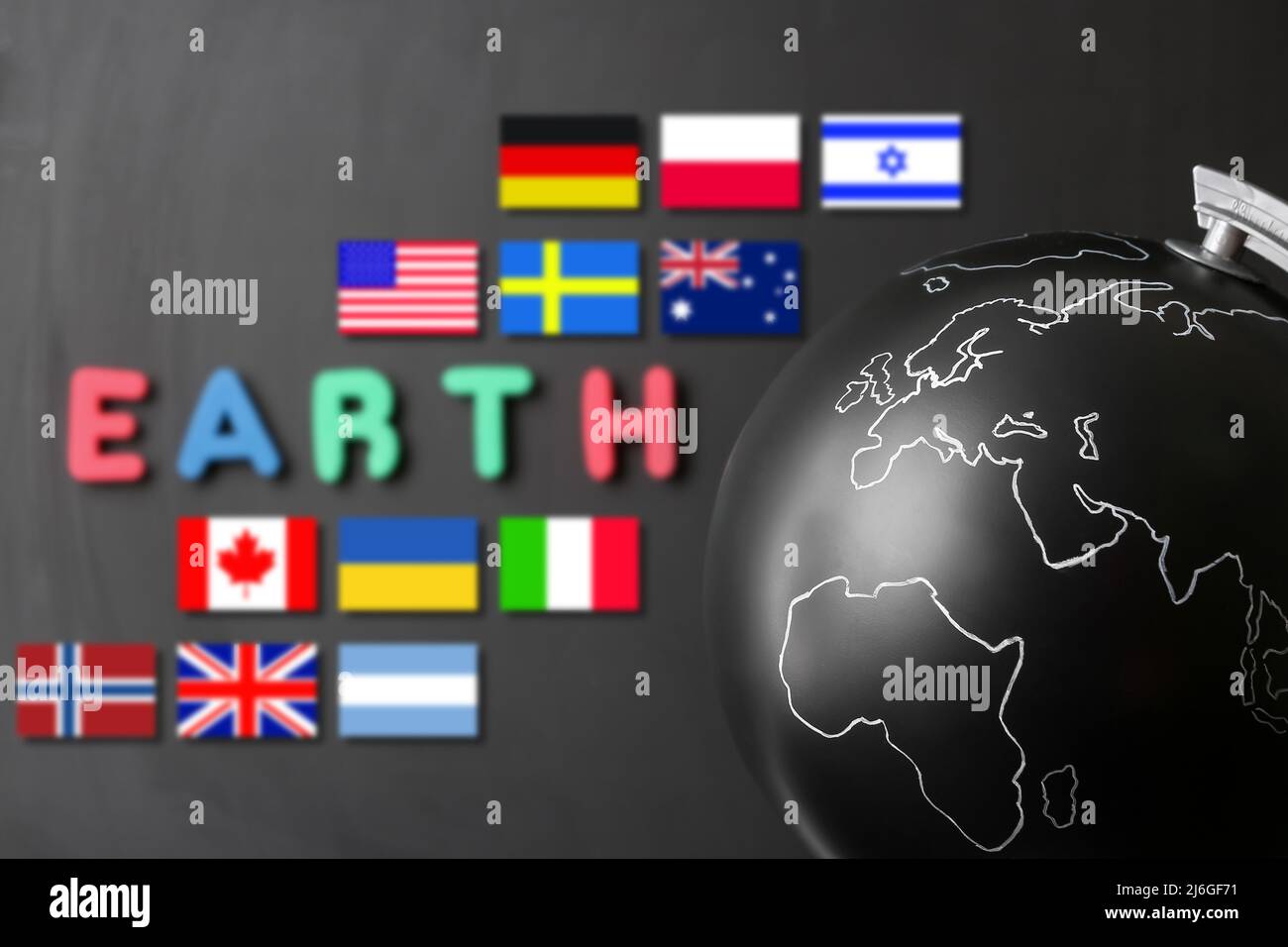 Globe against dark background with word EARTH and different flags Stock ...