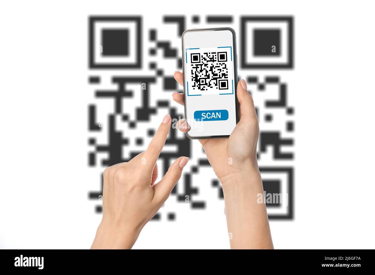 Hands of woman with smartphone scanning QR code on white background ...