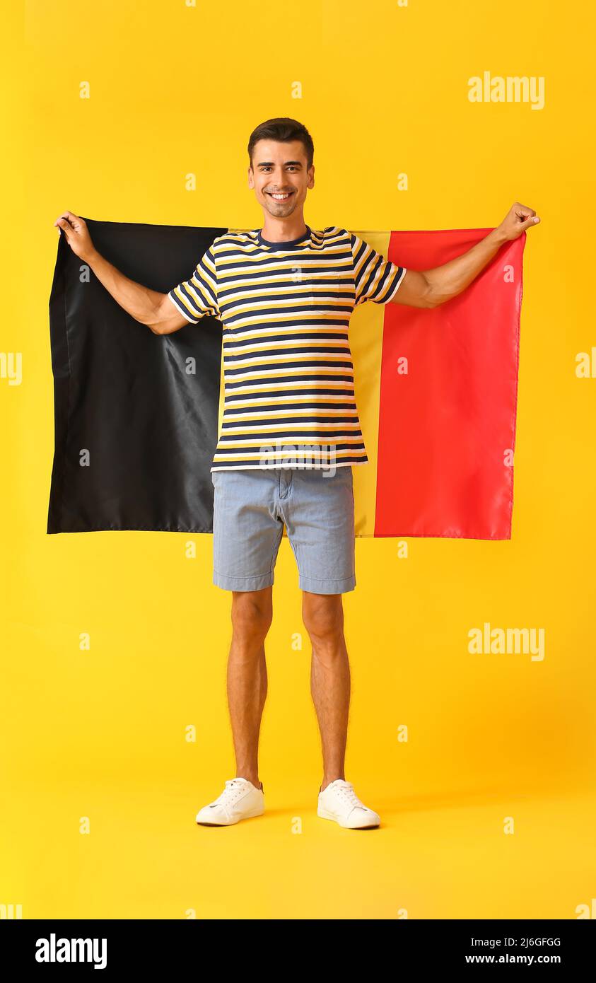 Young man with flag of Belgium on color background Stock Photo - Alamy