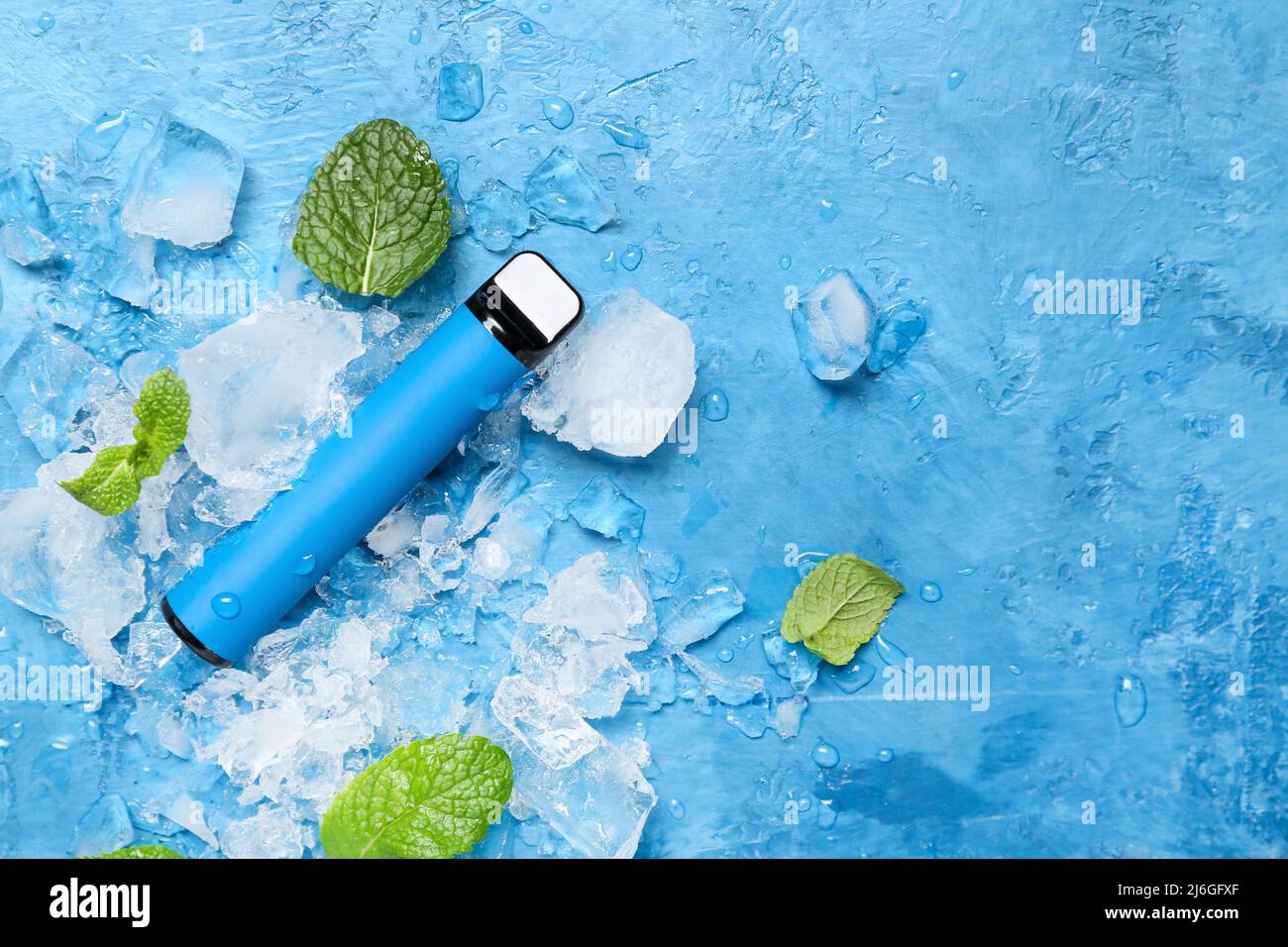 Disposable electronic cigarette, mint and ice cubes on blue background ...