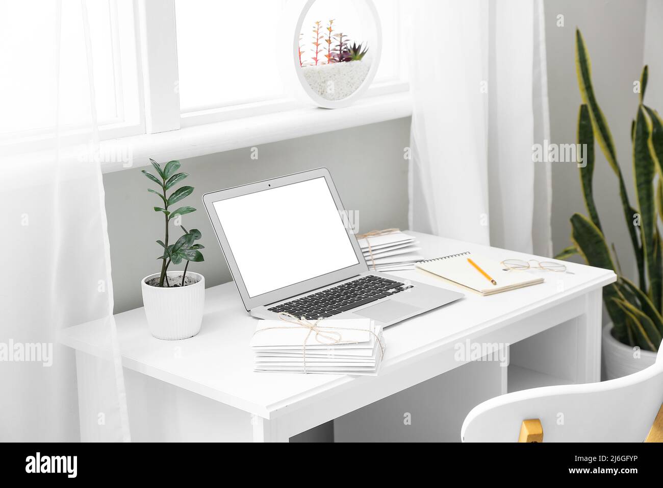 Workplace with modern laptop and letters near window in room Stock ...