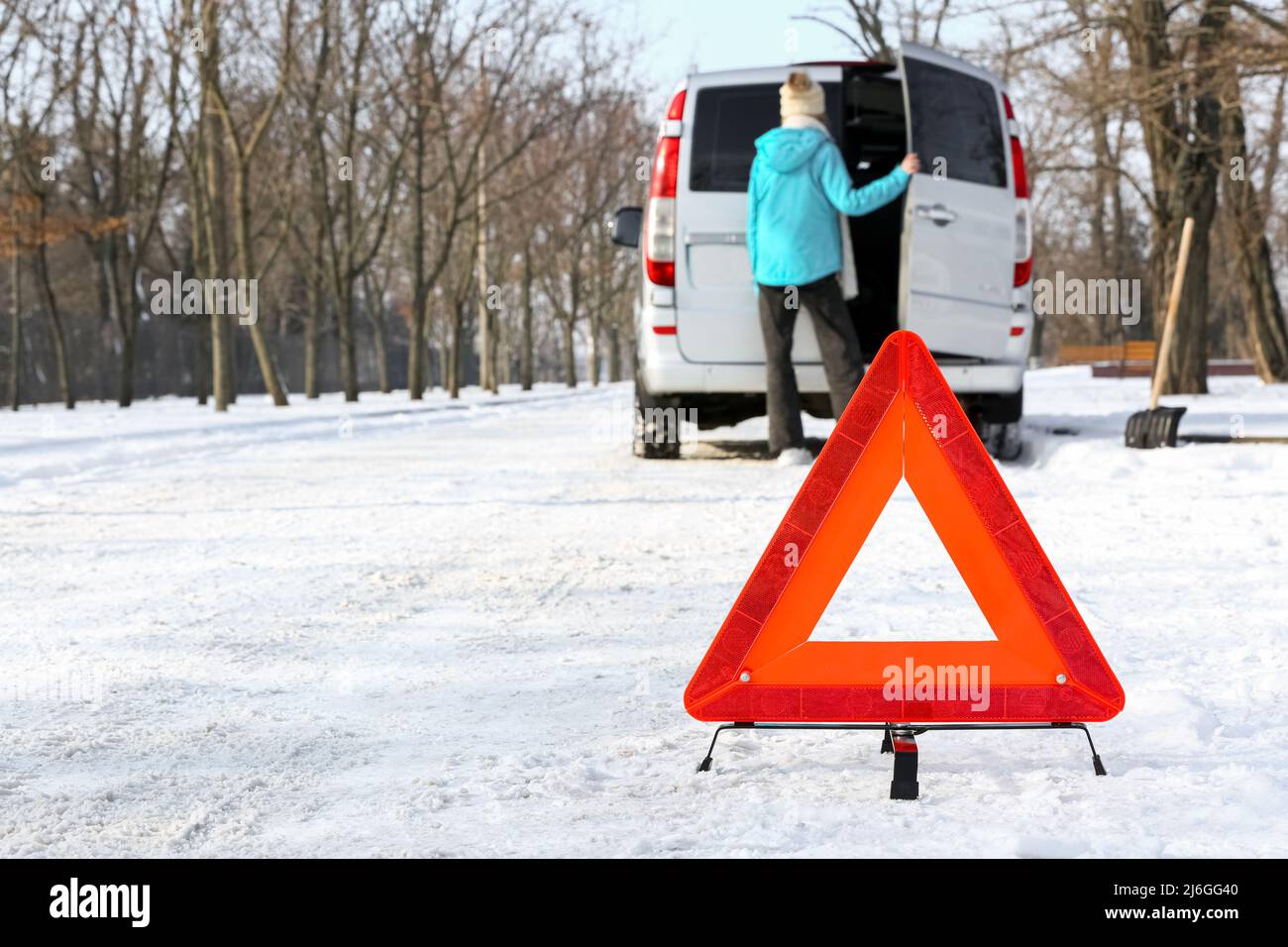Emergency stop sign and woman near broken car on cold winter day Stock ...