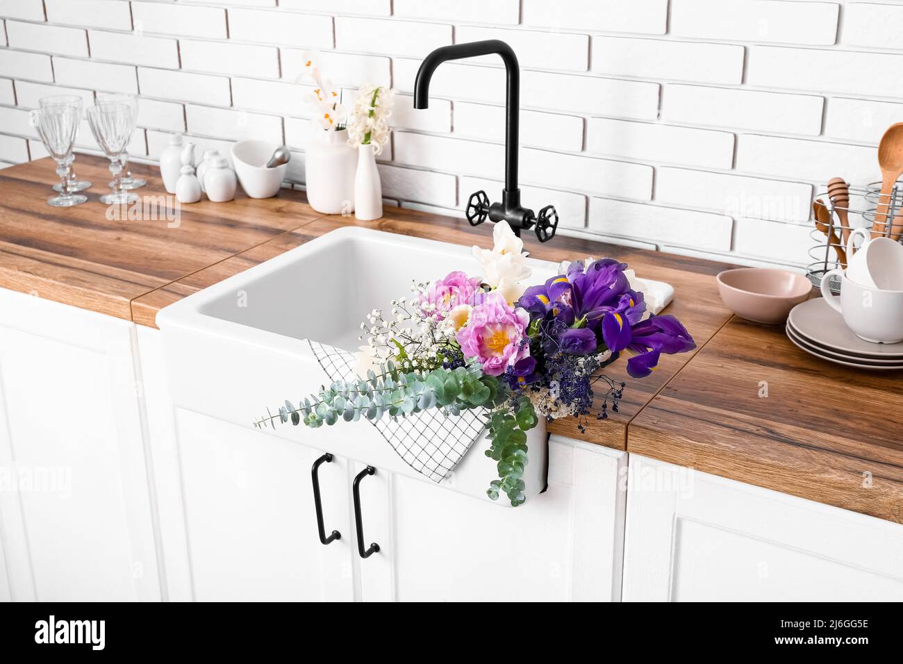 Sink with beautiful flowers on counter in kitchen Stock Photo - Alamy