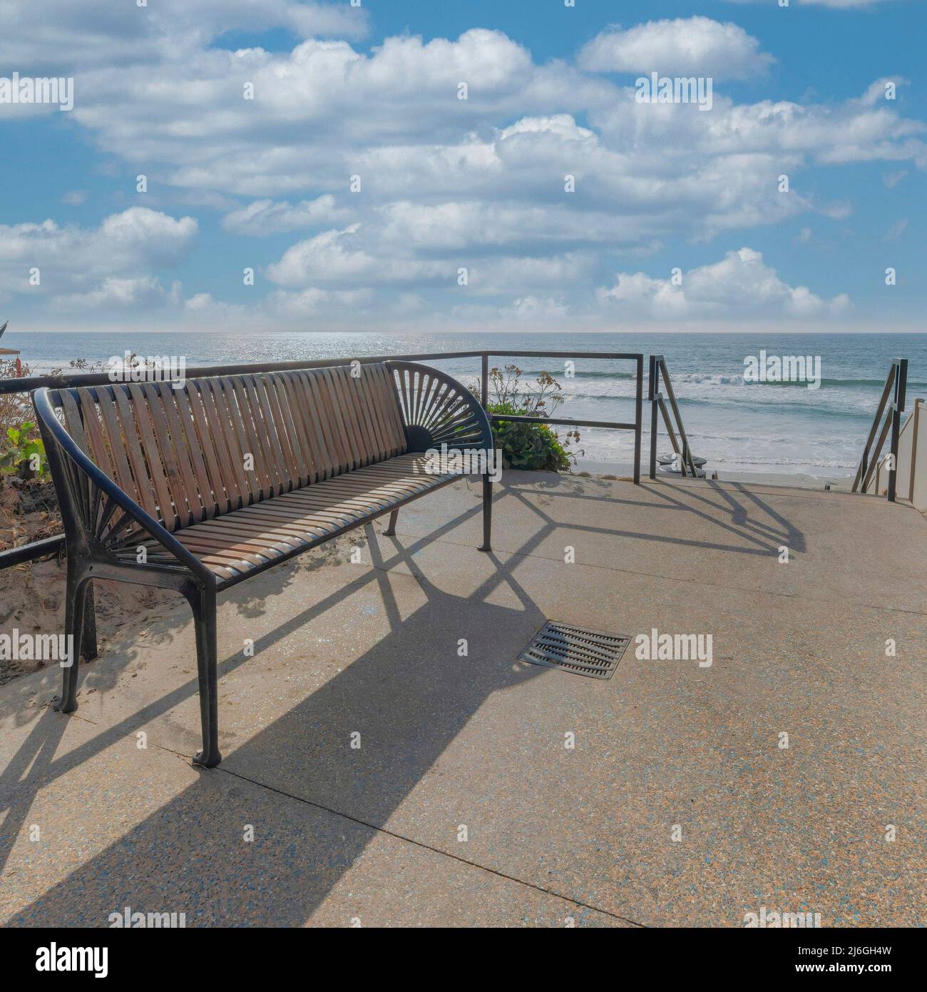 Square White puffy clouds Bench at the side of the pathway with ...