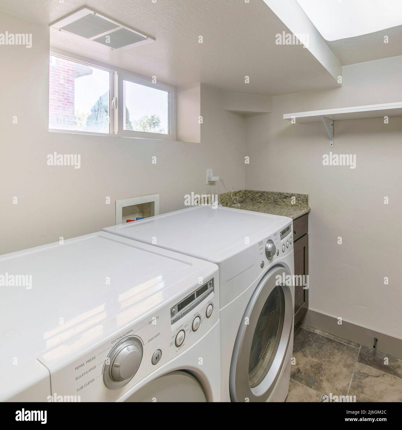 Square Laundry room interior with window and tile flooring Stock Photo ...