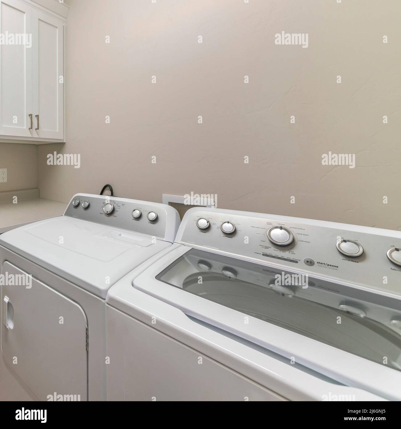 Square Interior of a laundry room with top cabinets and countertop ...