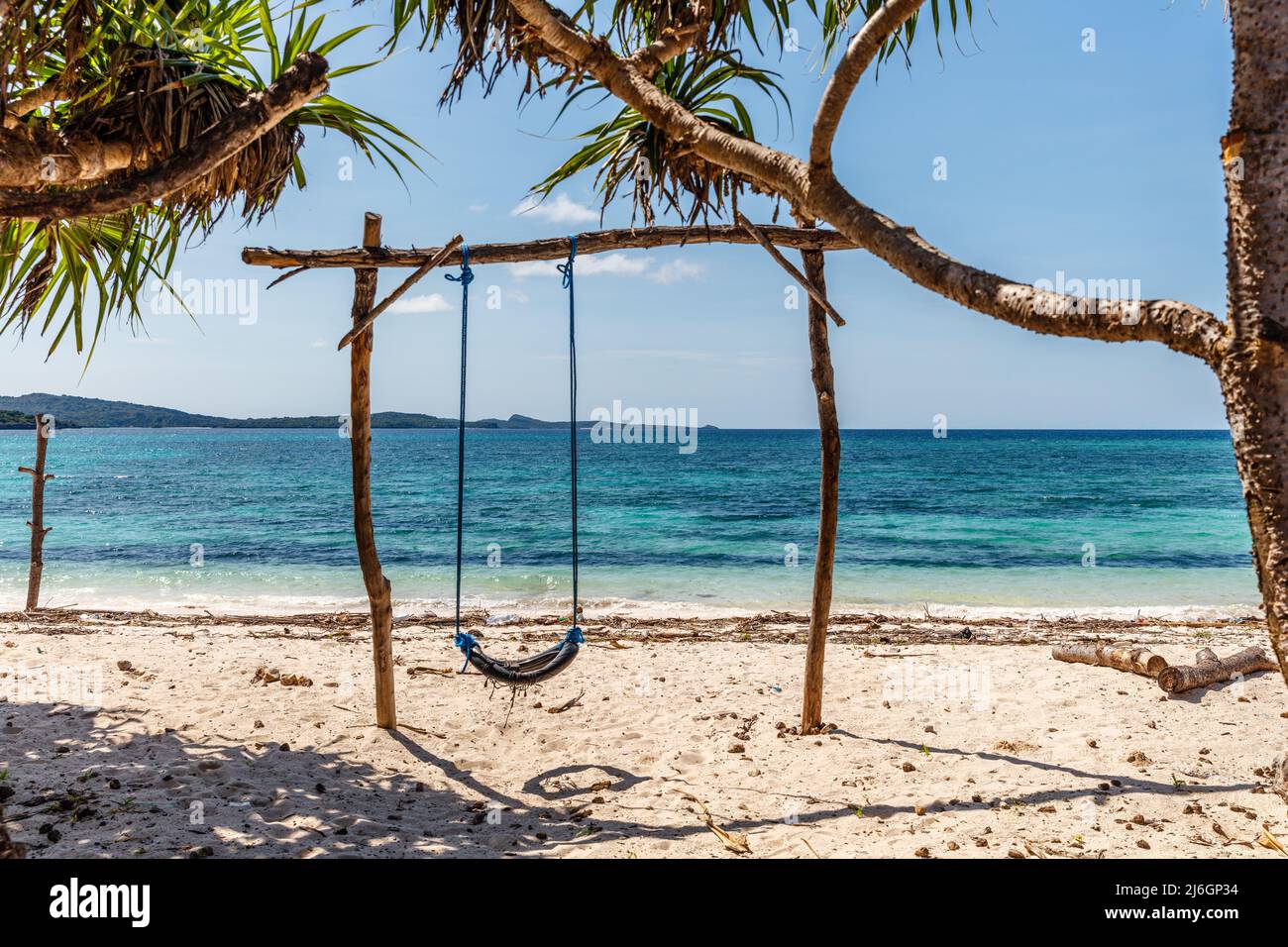 White sand Loedi Beach with pandan trees and a swing at Rote Island ...
