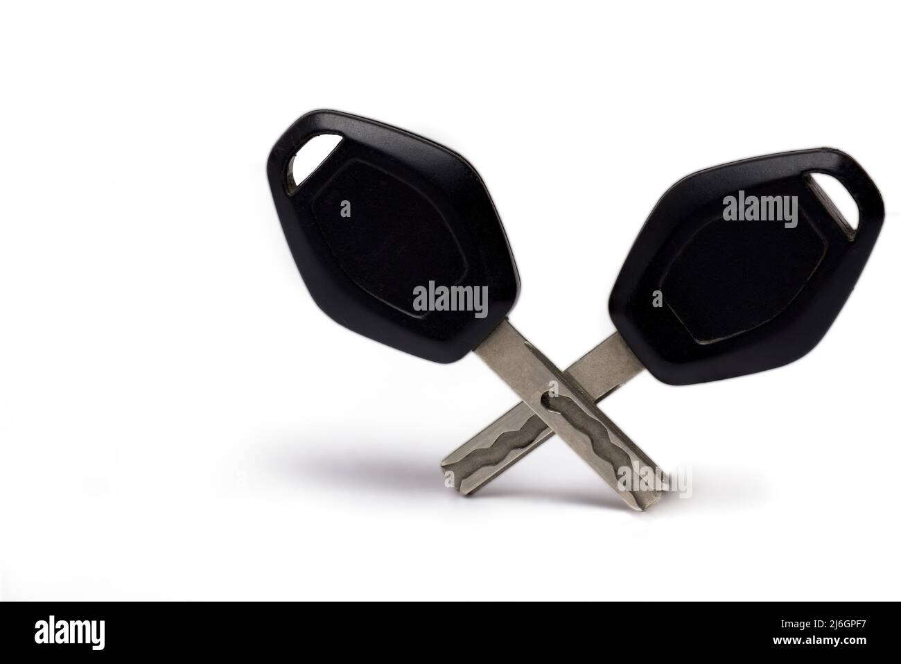 Close up of two crossed modern car keys on white background as concept ...
