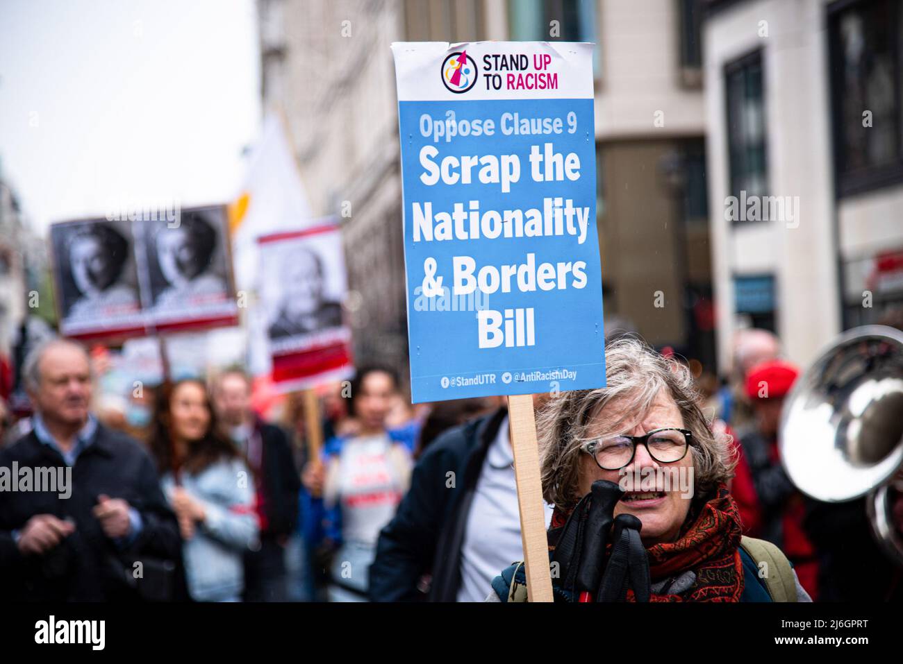 An activist holds a placard that says, "Scrap the Nationality & Borders ...