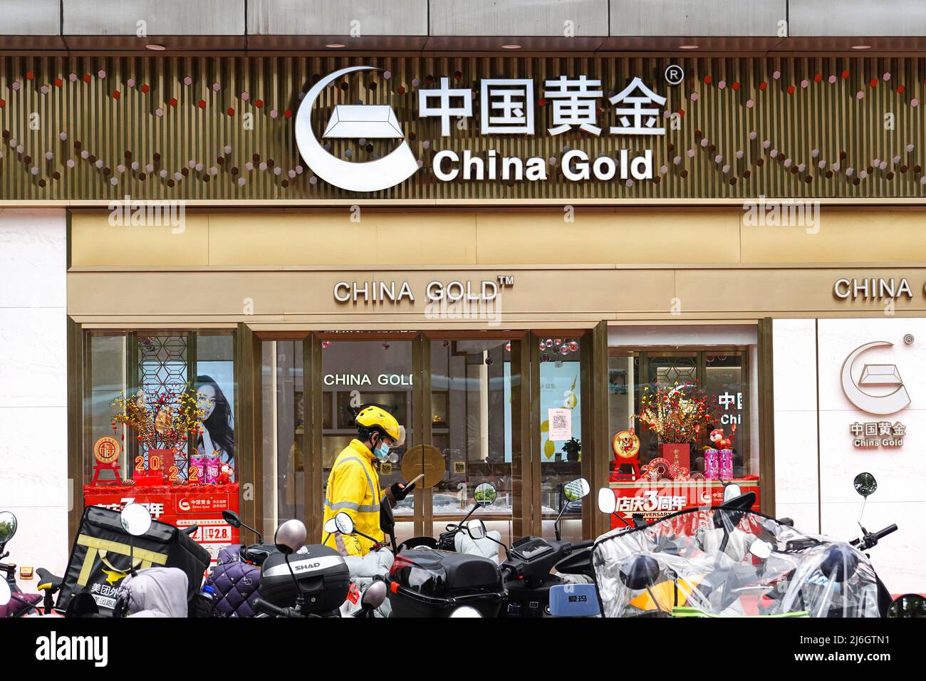 A delivery man walks past the China Gold Store. (Photo by Sheldon ...