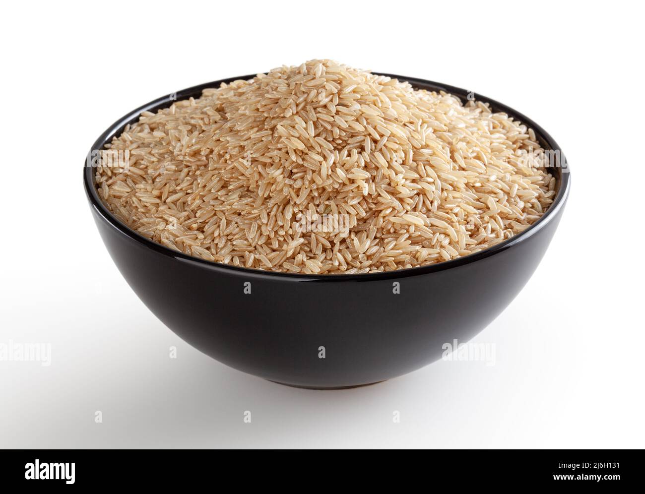 Brown rice in black bowl isolated on white background with clipping ...