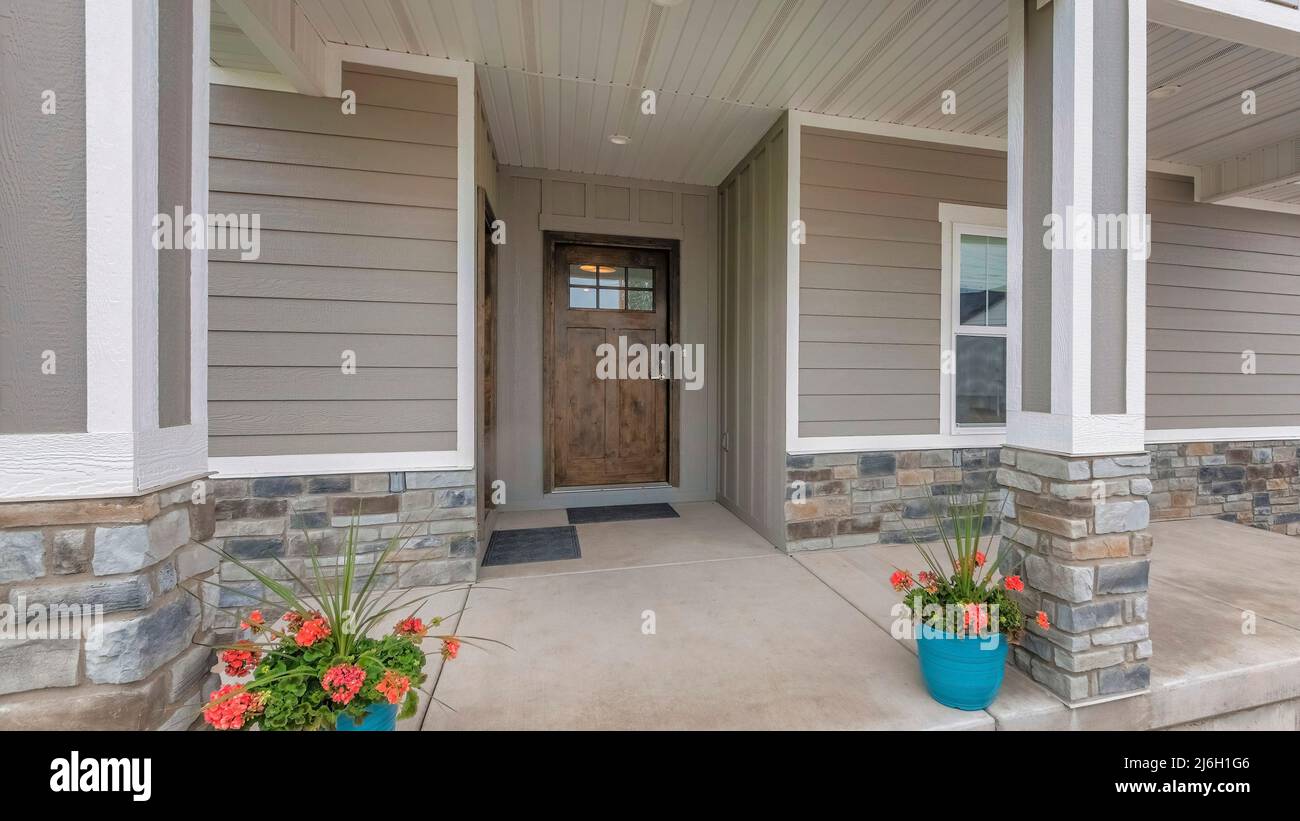 Panorama Front porch with two wooden front doors and potted flowers ...