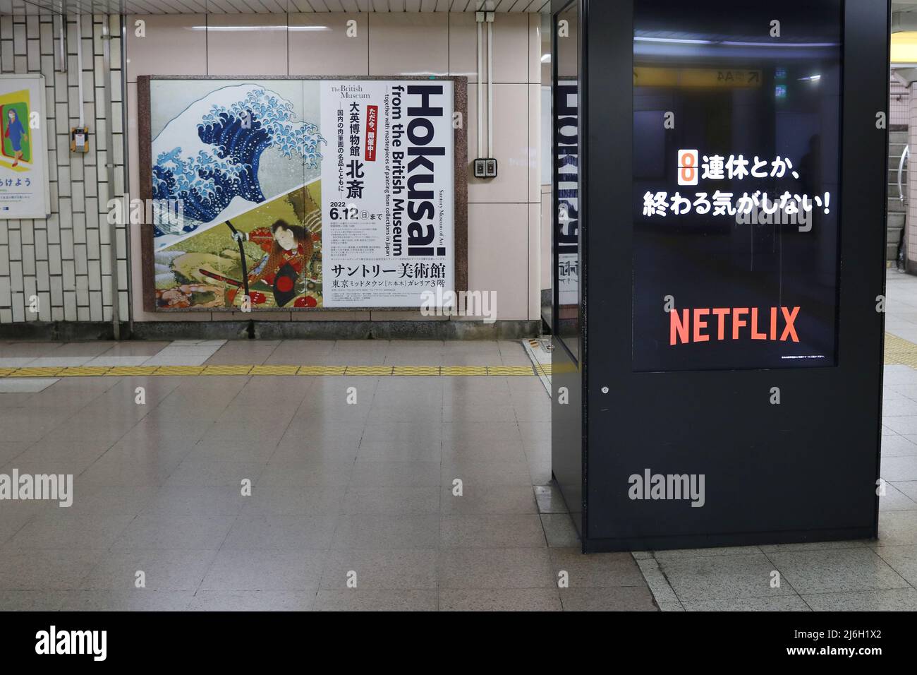 TOKYO, JAPAN - May 1, 2022: Screens advertsing Netflix and a poster ...