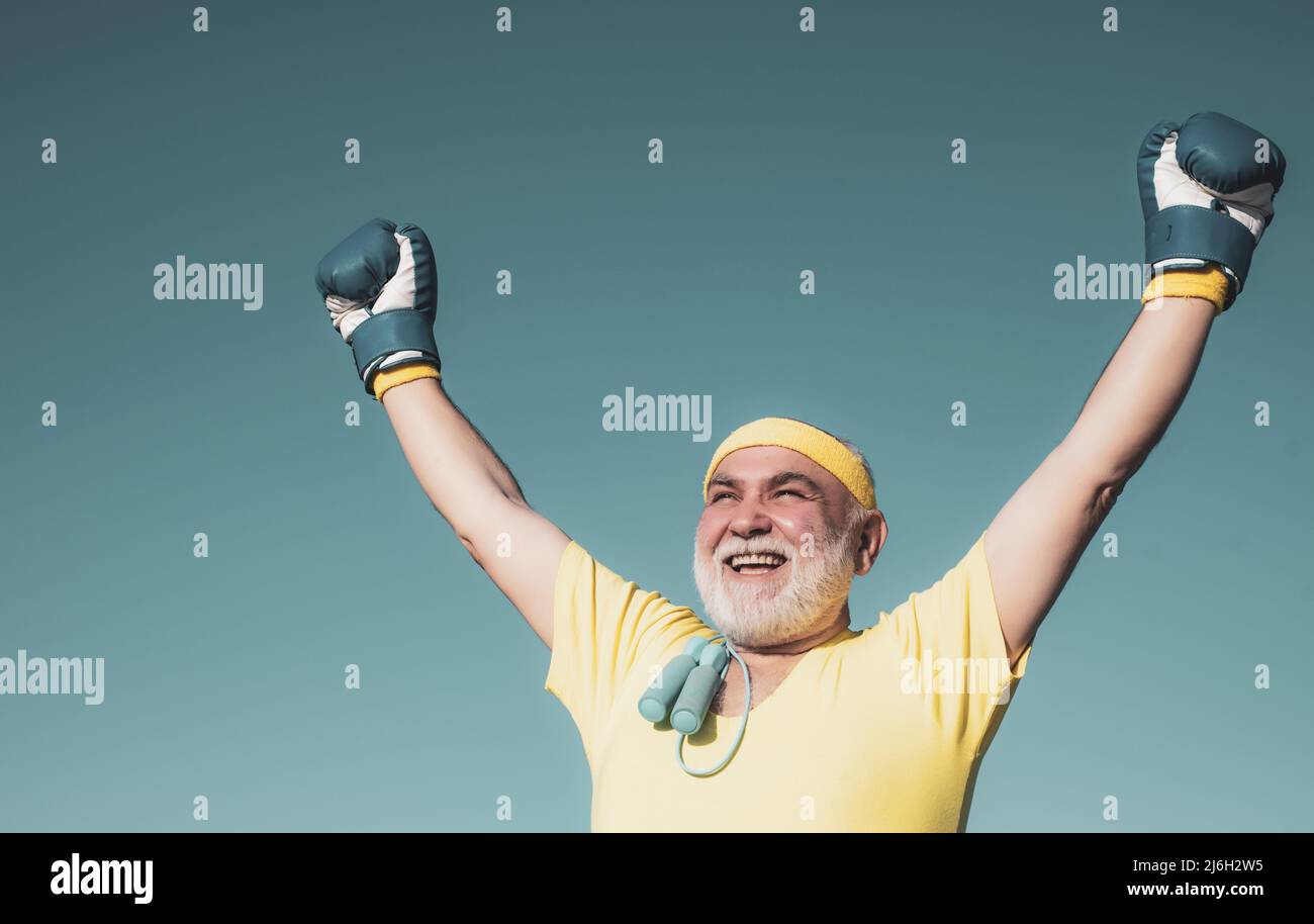 Happy Senior man wearing boxing gloves. Portrait of a determined senior ...