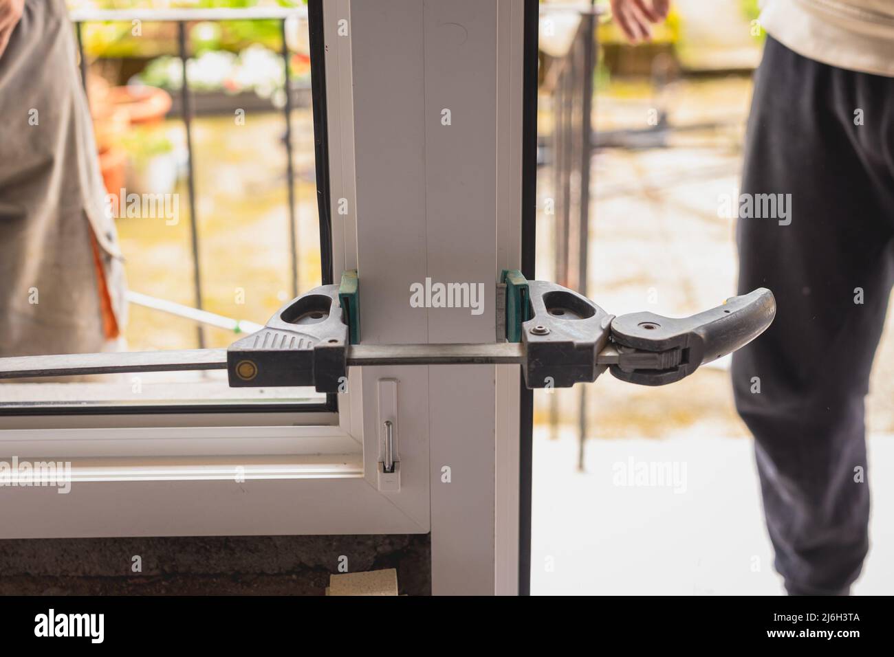 Using a metal clamp to clamp new windows together while being drilled ...