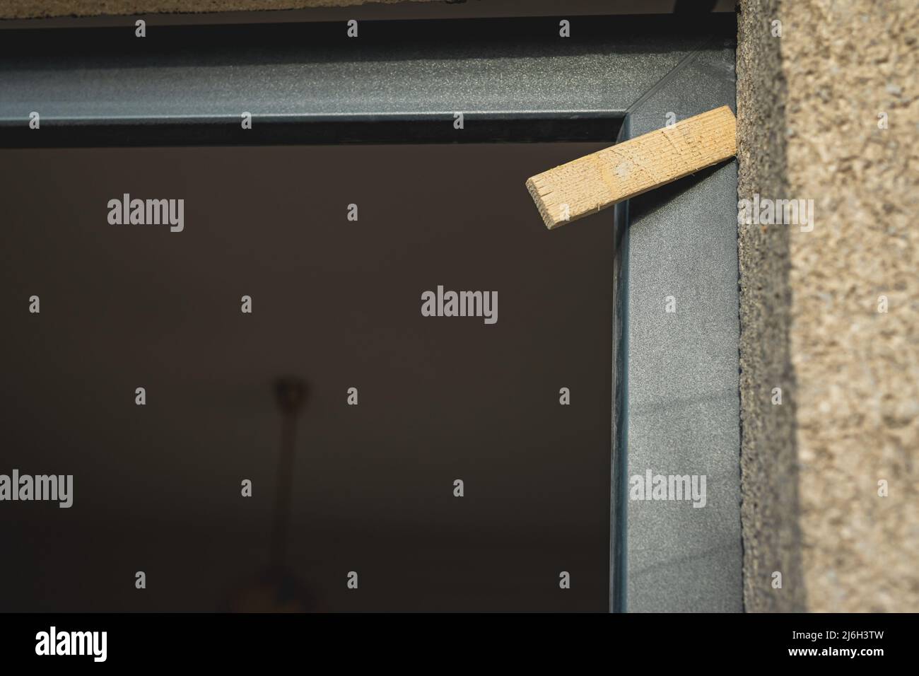 Two wooden chocks or drifts are used to position the new window in an ...