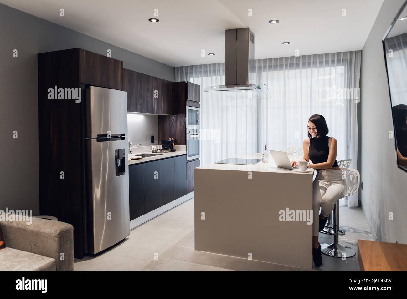 Beautiful business woman is using a laptop, looking at camera and ...