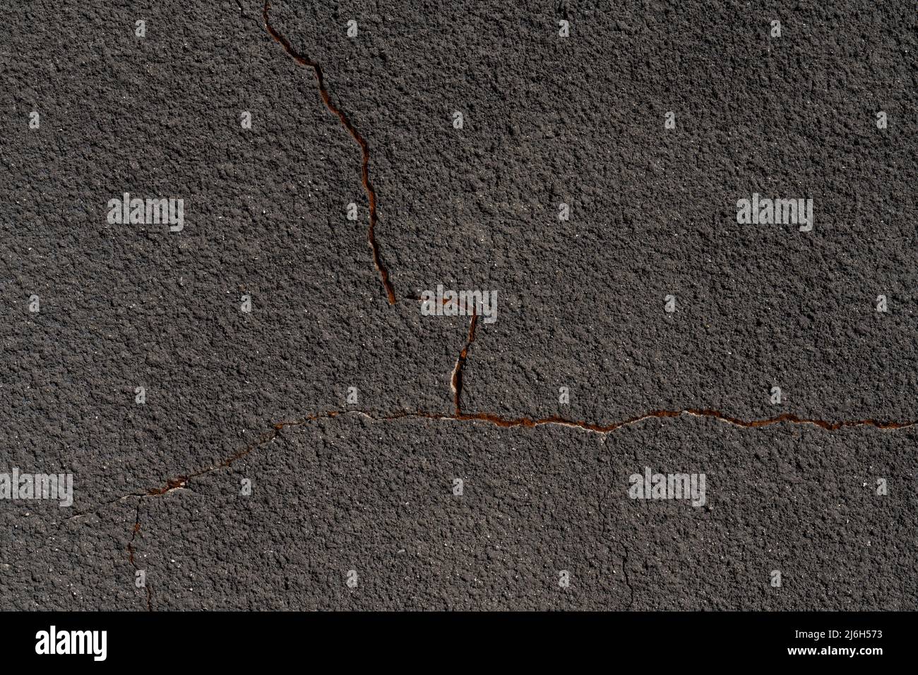 Gray wall with a crack. Texture of rough plaster with uneven granular ...