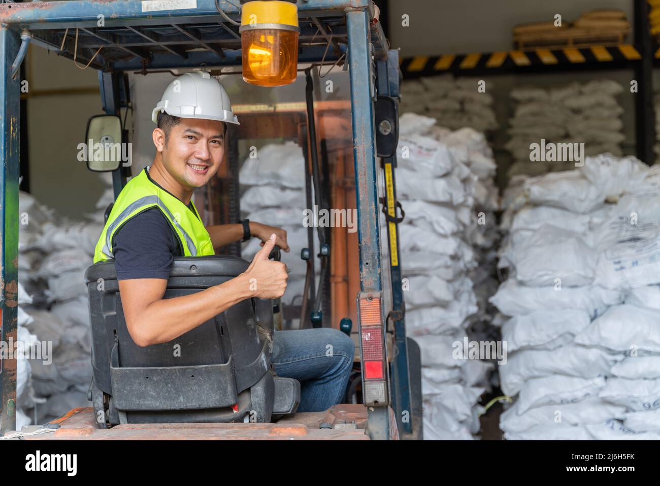 A Worker driving a forklift in alum or chemical warehouse Stock Photo ...