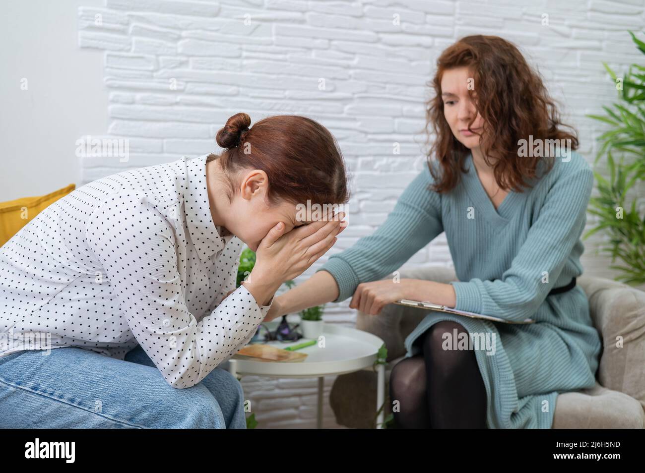 Caucasian woman crying at psychotherapy session. The female doctor ...