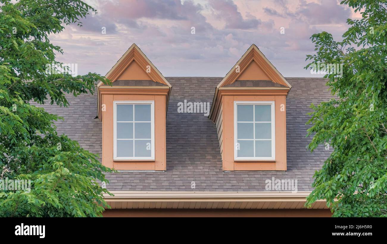 Panorama Puffy clouds at sunset Roof of a house with two gabled dormer ...