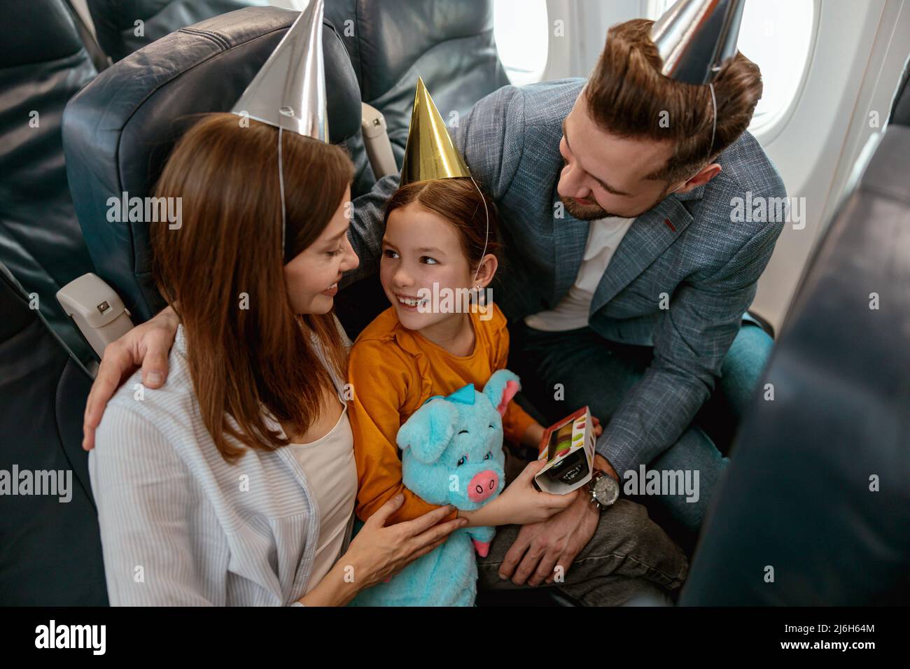 Happy parents celebrating daughter birthday during flight Stock Photo ...