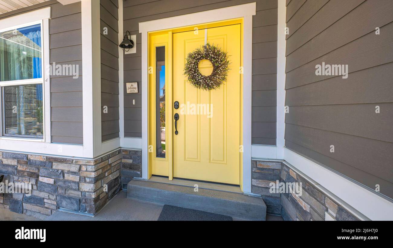 Panorama Yellow front door with wreath and sidelight at the entrance of ...