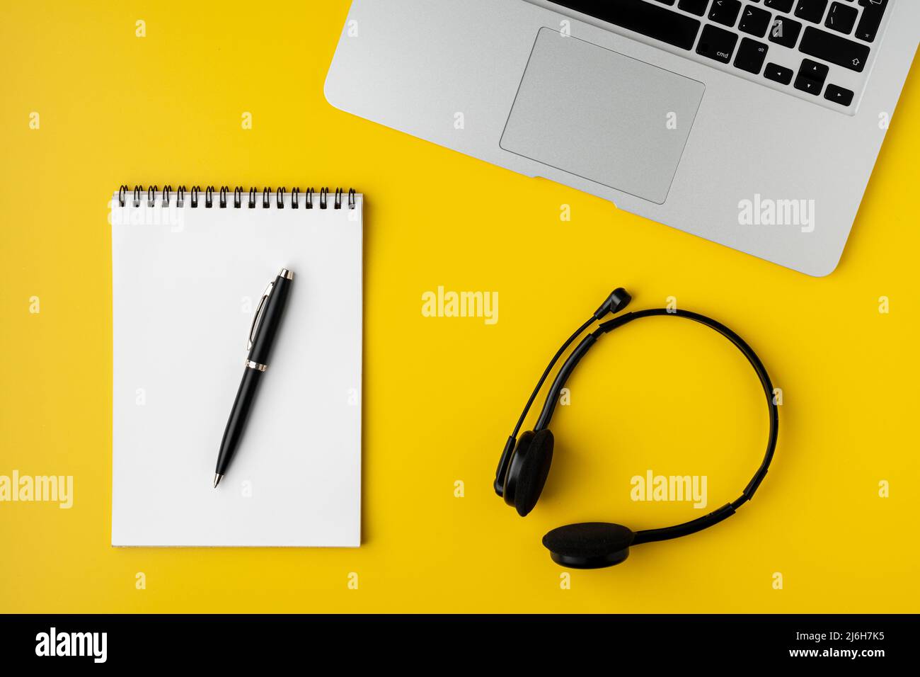 Contemporary workspace on yellow background. Notebook with pen, laptop ...