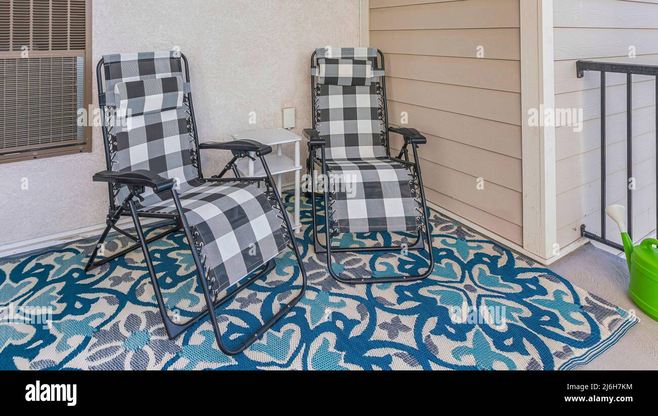 Panorama Porch of a house with two lounge chairs and carpet with blue ...