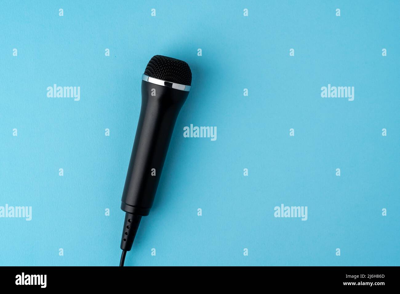 Black microphone in metallic tones, shallow depth of field on blue ...