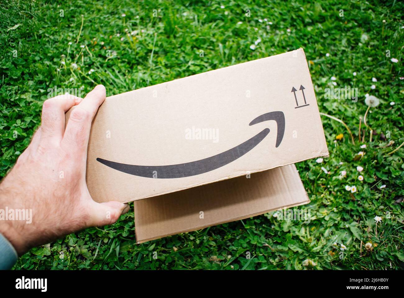 Paris, France - April 29, 2022: POV male hand holding Amazon cardboard ...
