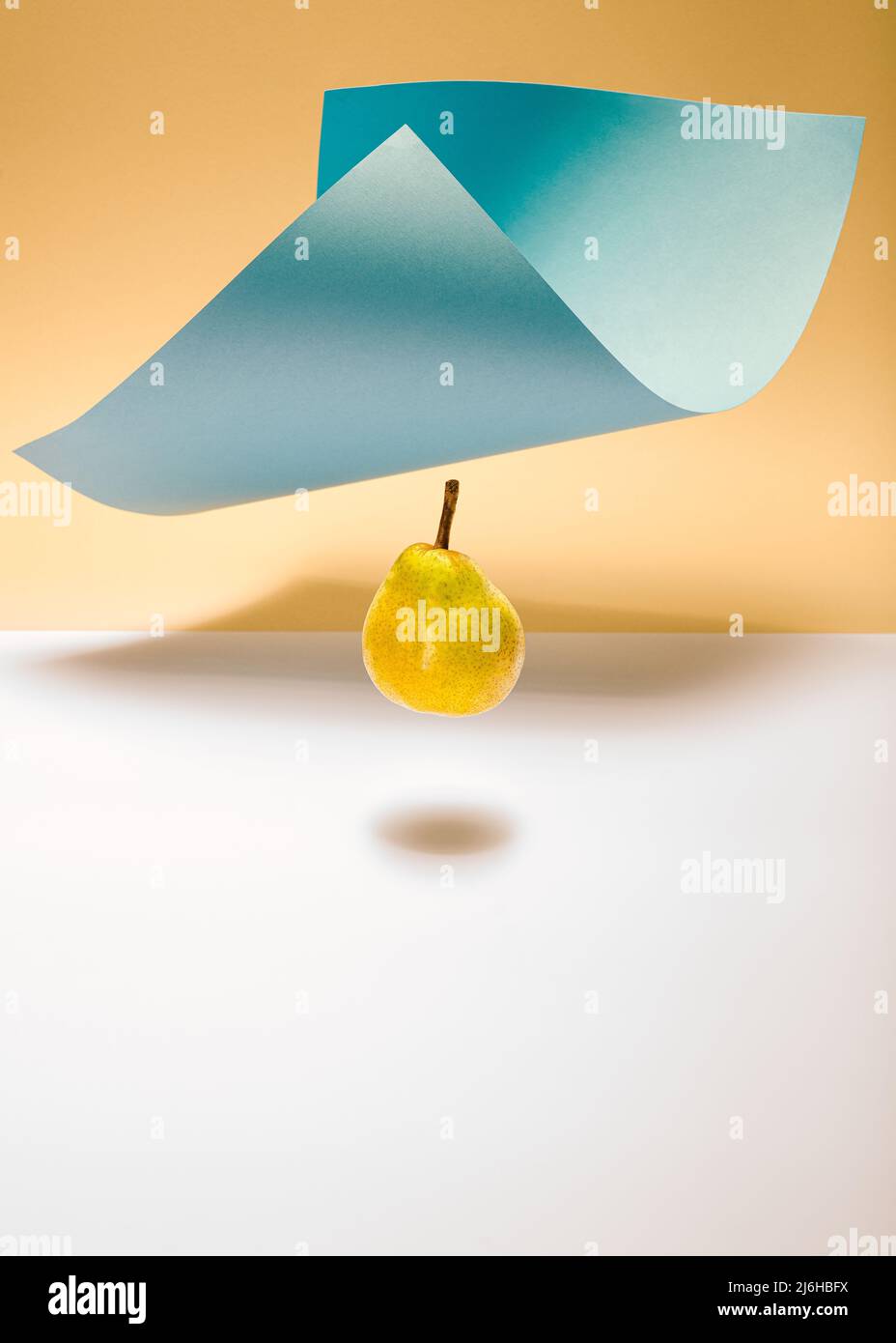 A Floating Pear with a Light Blue Shape on a Yellow Background Stock ...