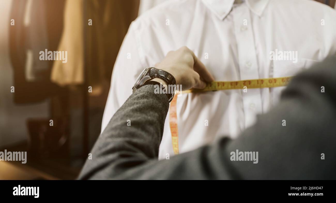 Detail of tailor's hands taking measurements from client. Made Cloth ...