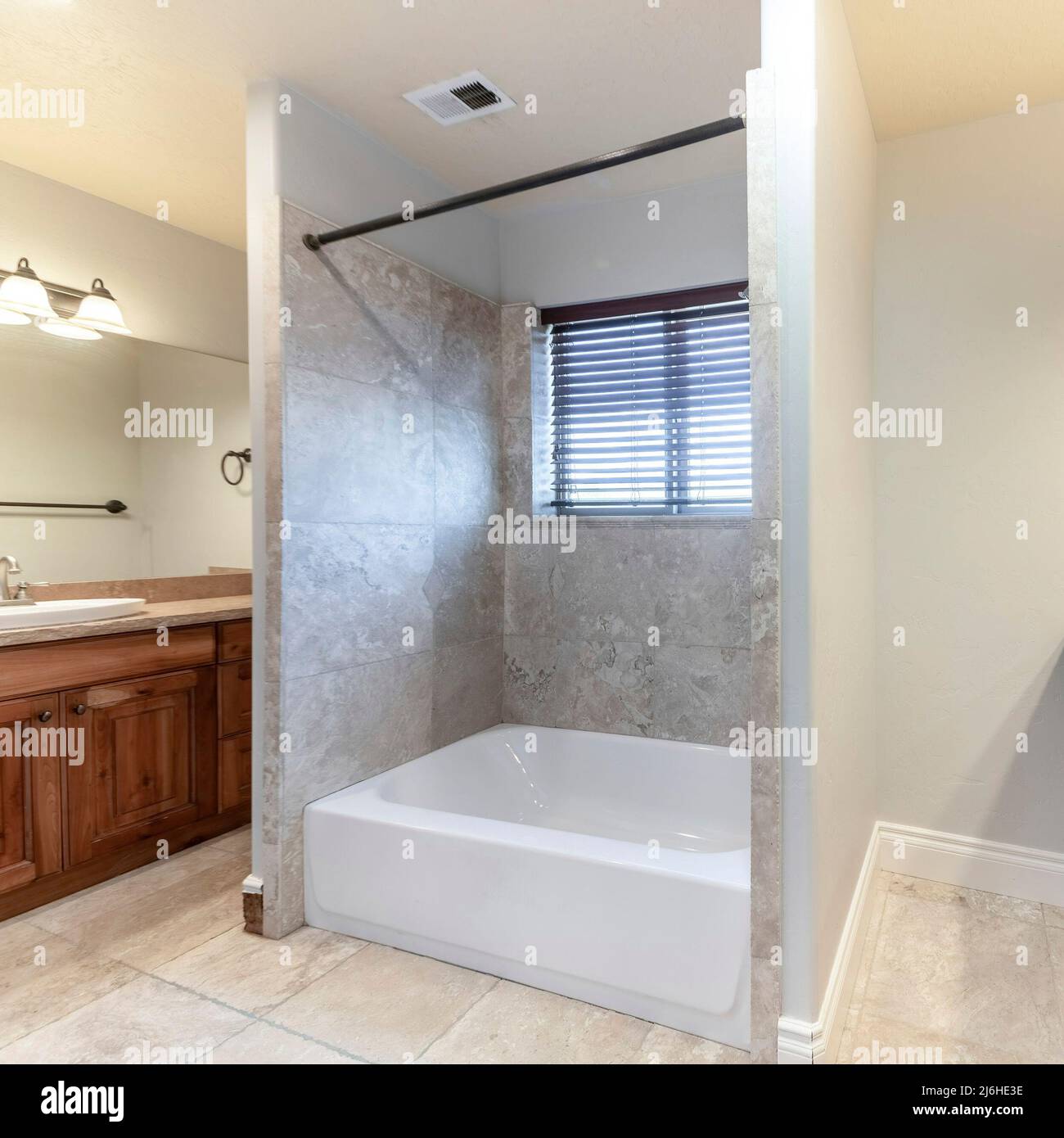 Square Master bathroom with bathtub in the middle of two vanities Stock ...