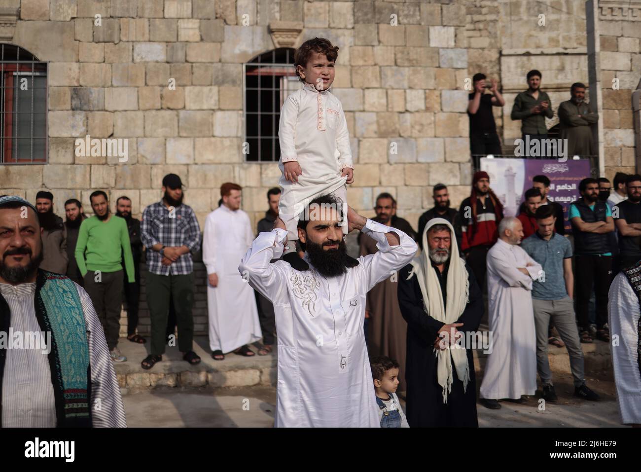 02 May 2022, Syria, Idlib: Syrian Muslims stand in front of a mosque in ...
