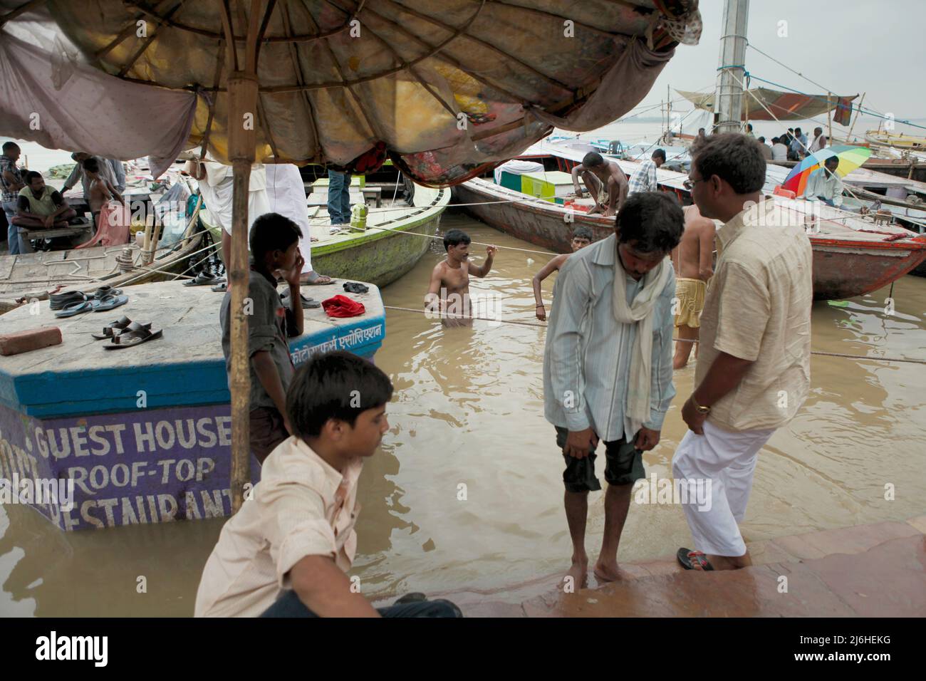 Pilgrims take a bath ritual, as the others are standing and sitting on ...