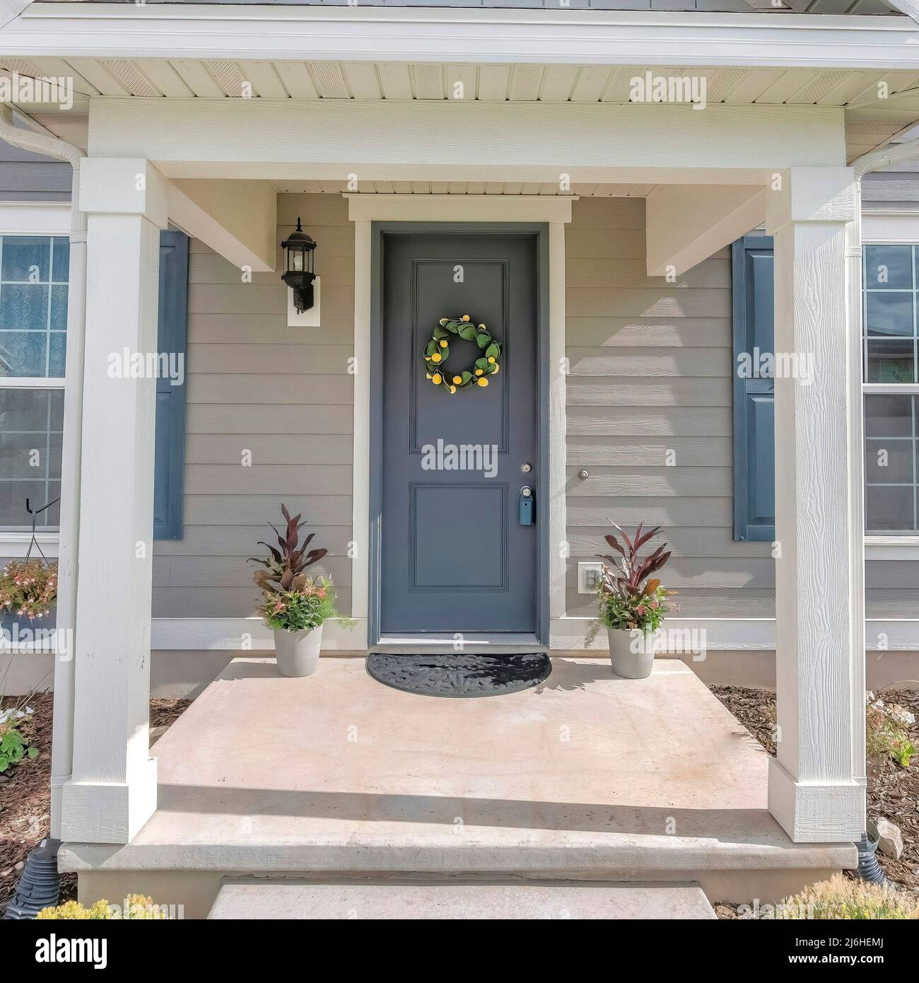 Square Symmetrical house facade with vinyl wood siding and gray front ...