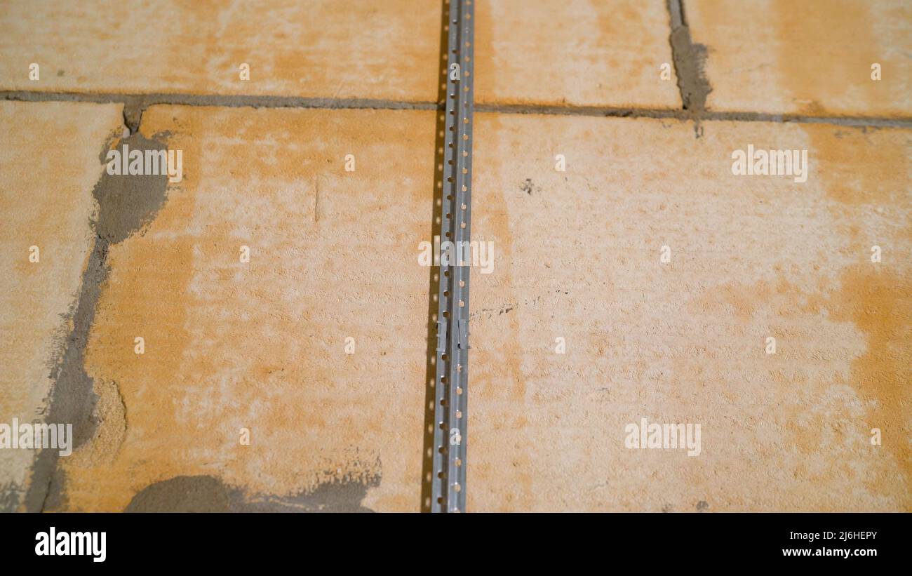 Installation of beacons for leveling the wall. Installation of metal ...