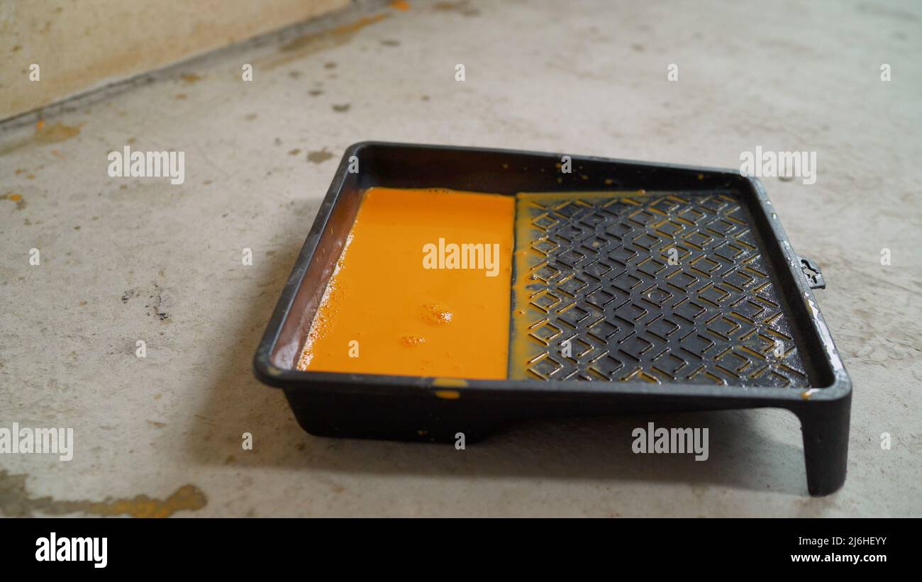 Orange primer in the tray. Primer is poured into a paint tray Stock ...