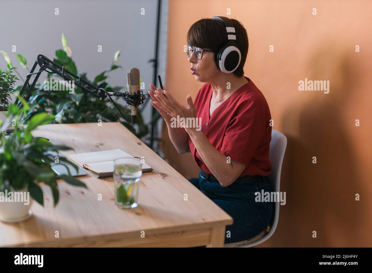Middle-aged woman radio host making podcast recording for online show ...