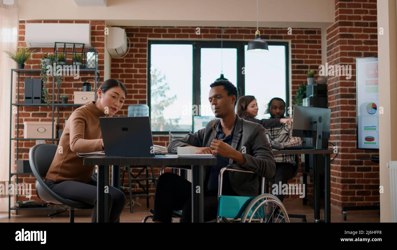 African american man with handicap talking to colleague about business ...
