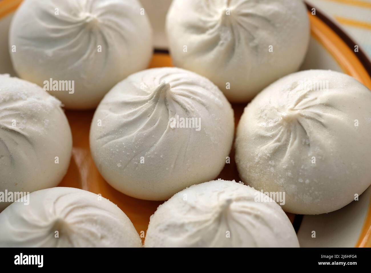 Frozen khinkali on a plate close-up. Raw khinkali stuffed with meat ...