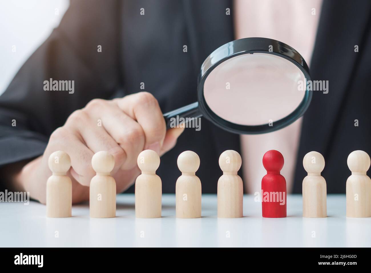 Businesswoman hand holding magnifying glass for recruiting leader man ...