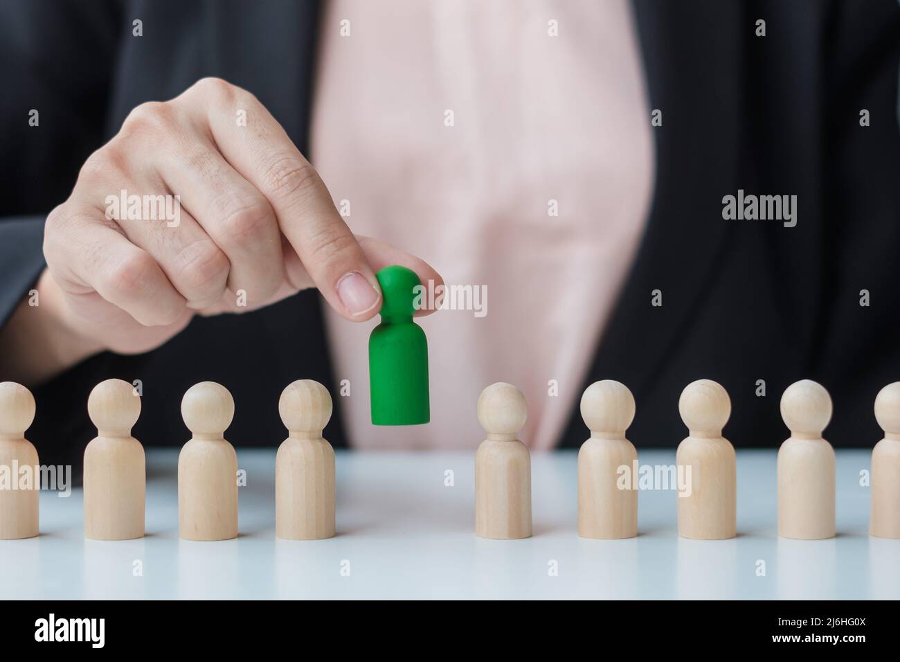 Businesswoman hand pulling leader man wooden from crowd of employees ...