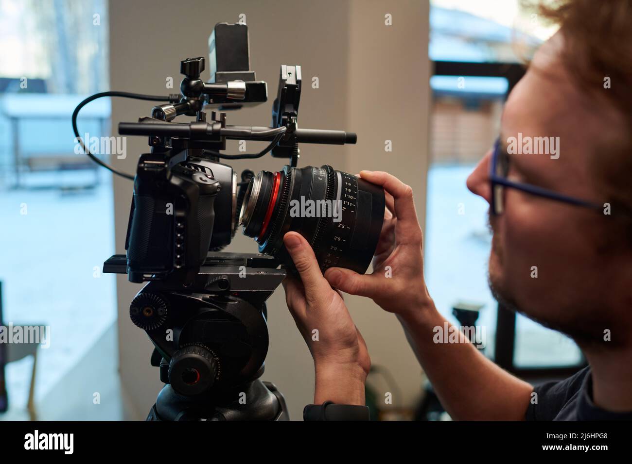 Hands of young cameraman turning video camera lens while adjusting ...