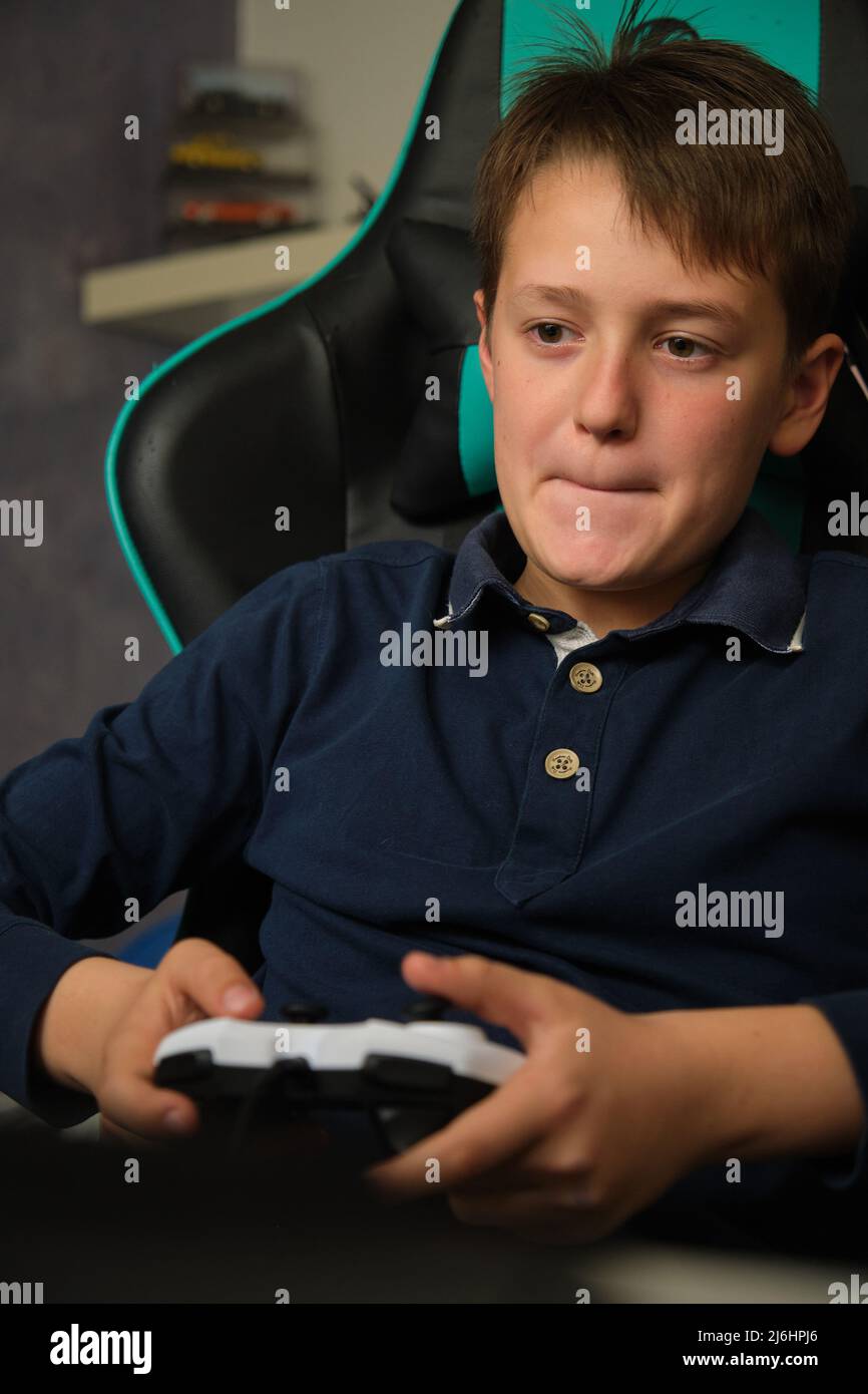the boy is playing a video game console Stock Photo - Alamy